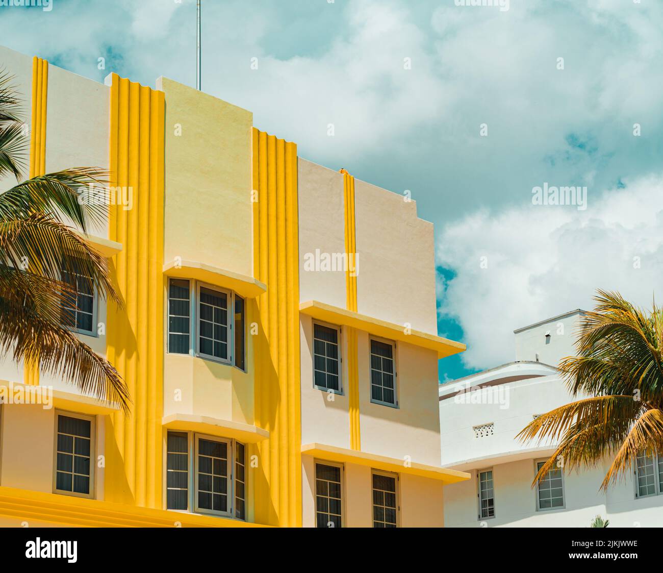 An exterior view of a building with yellow walls in cloudy sky ...