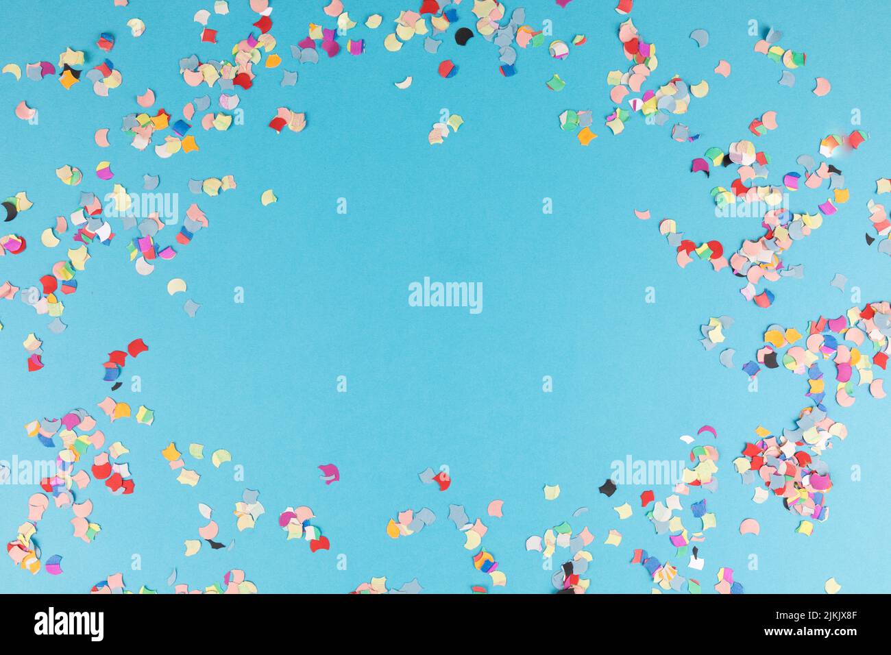 A blue background with colorful confetti and copy space Stock Photo - Alamy