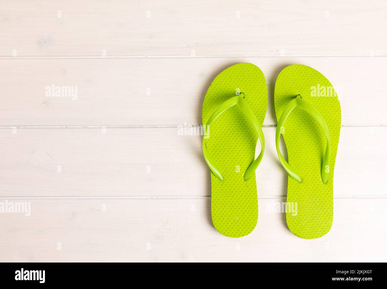 green flip flops on white wooden background with copy space Stock Photo ...