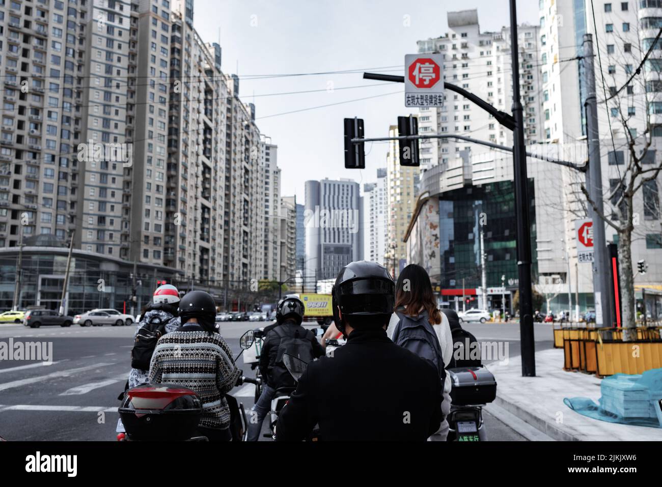 A back view of a group of motorcyclists waiting at a traffic light in ...