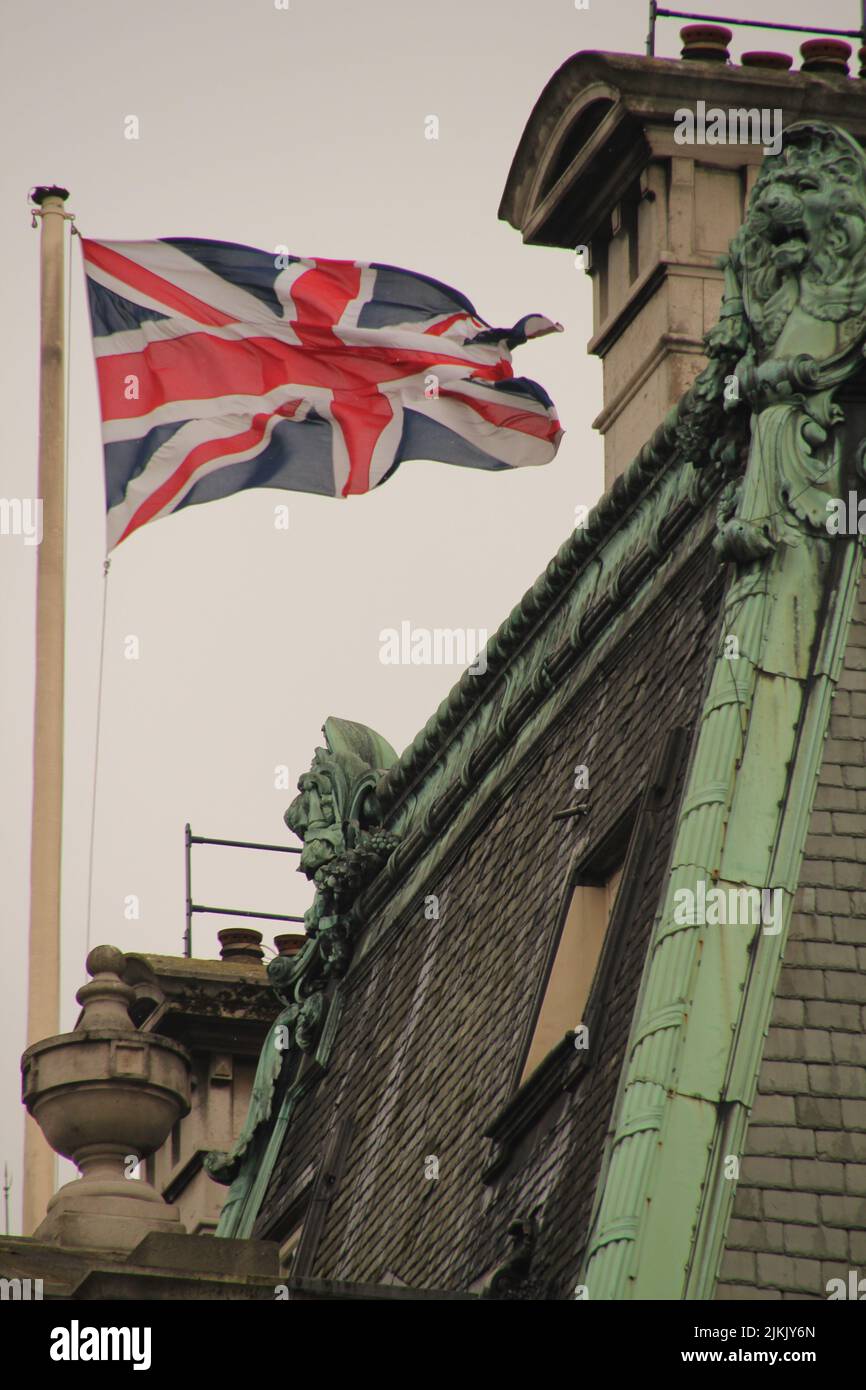 A vertical shot of the flag of Great Britain in front of the old ...