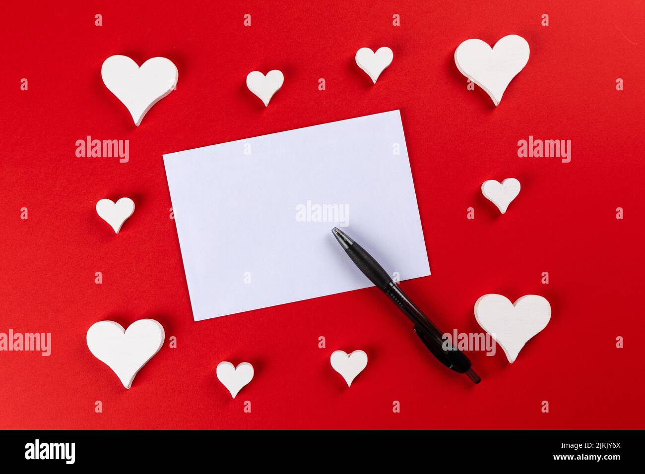top view with red background with hearts for writing a love letter for ...