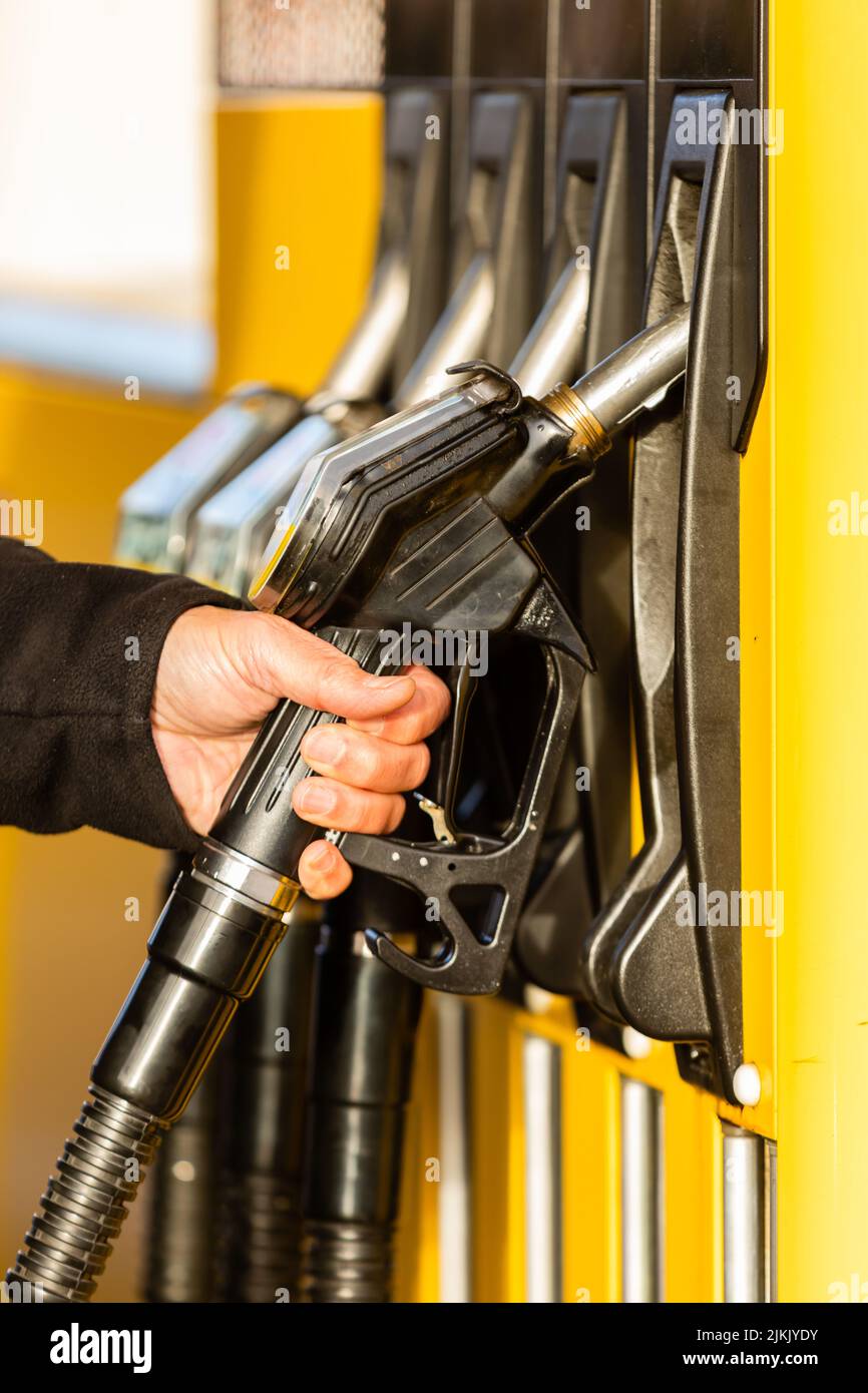 Hand with fuel nozzle at a gas station Stock Photo - Alamy