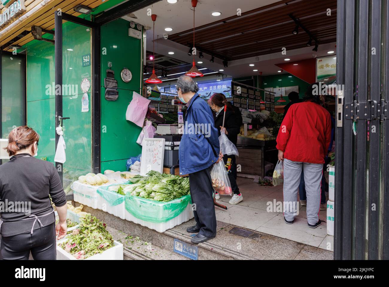 A group of people in a supermarket shopping for essentials in ...