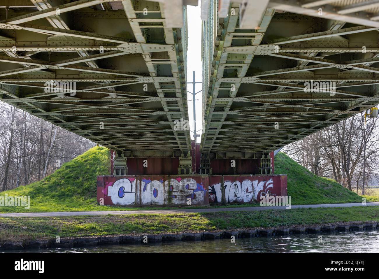 A view of the underside of a train bridge over a river in the ...