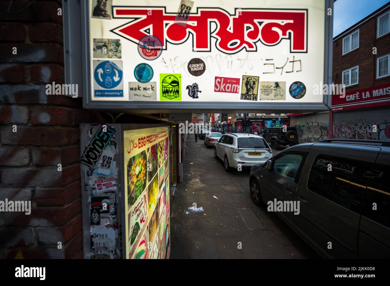 A beautiful shot of a shop sign with traffic cars in the street in ...
