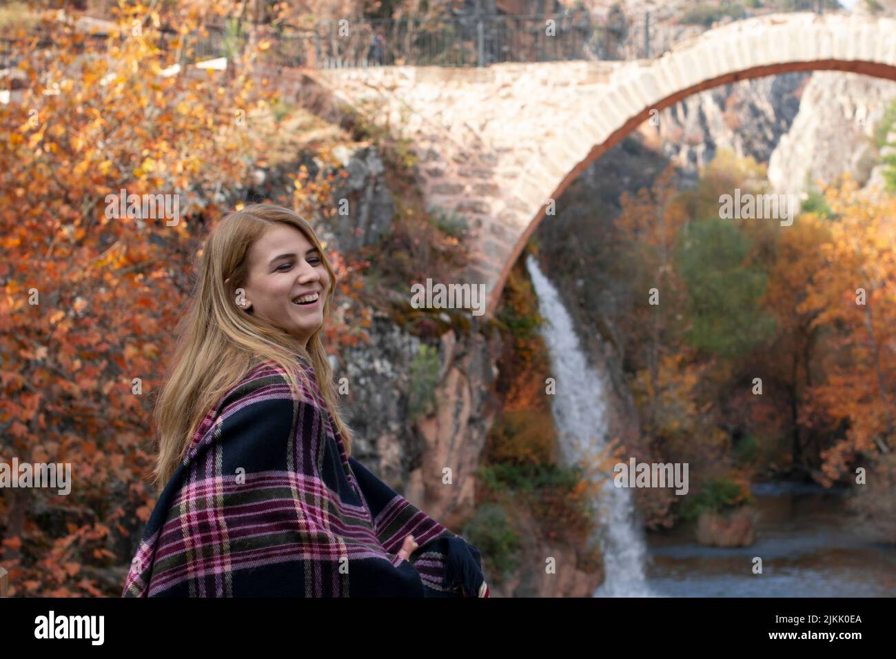 Young girl posing against out focus Clandras Bridge. Historical bridge ...