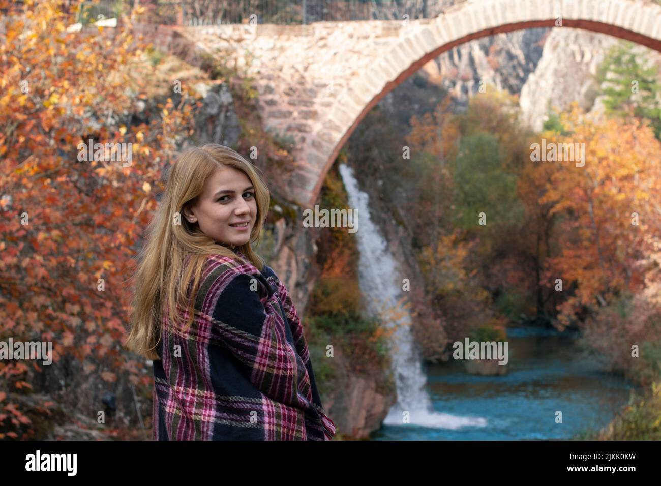 Young girl posing against out focus Clandras Bridge. Historical bridge ...
