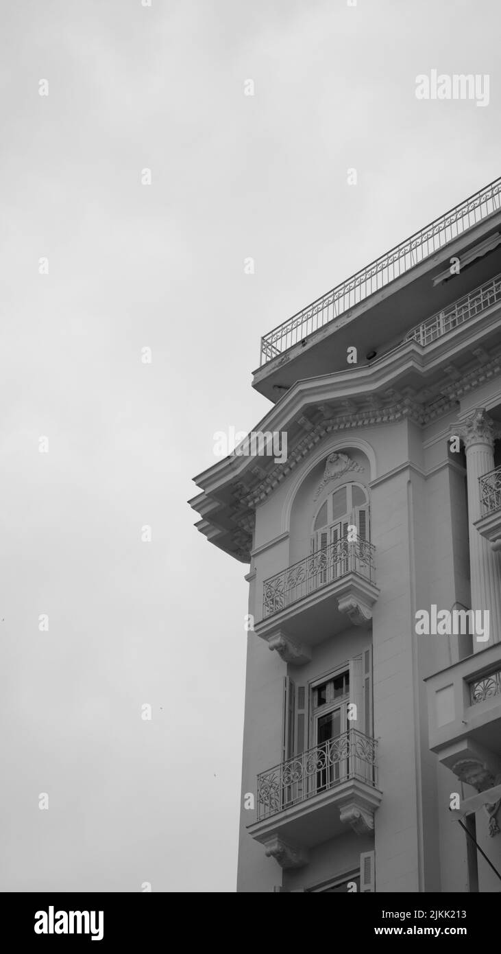 A vertical grayscale shot of a historic building on a cloudy sky ...