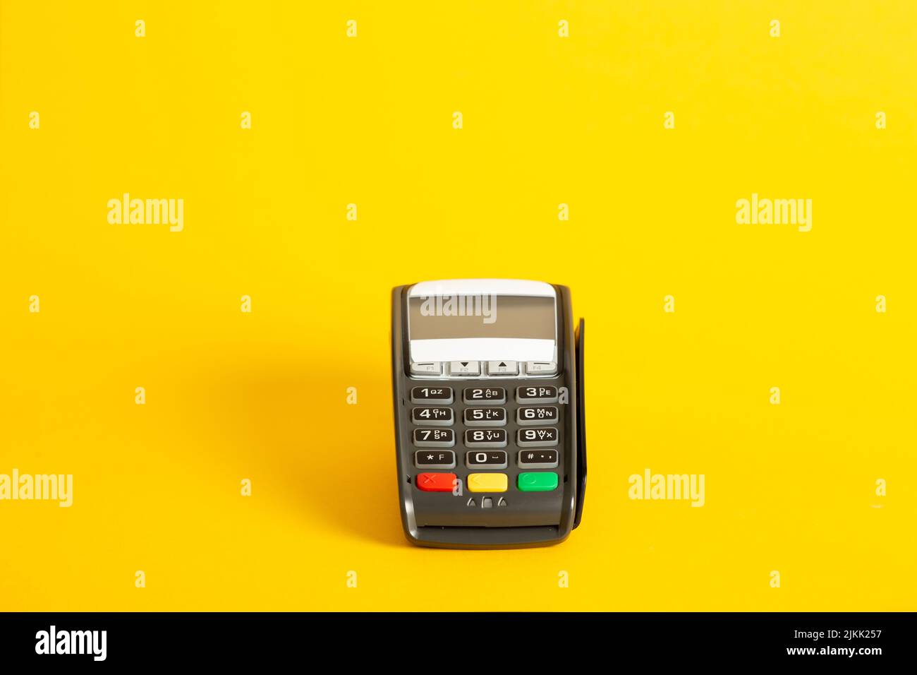 A closeup of an electronic payment terminal isolated on a yellow ...