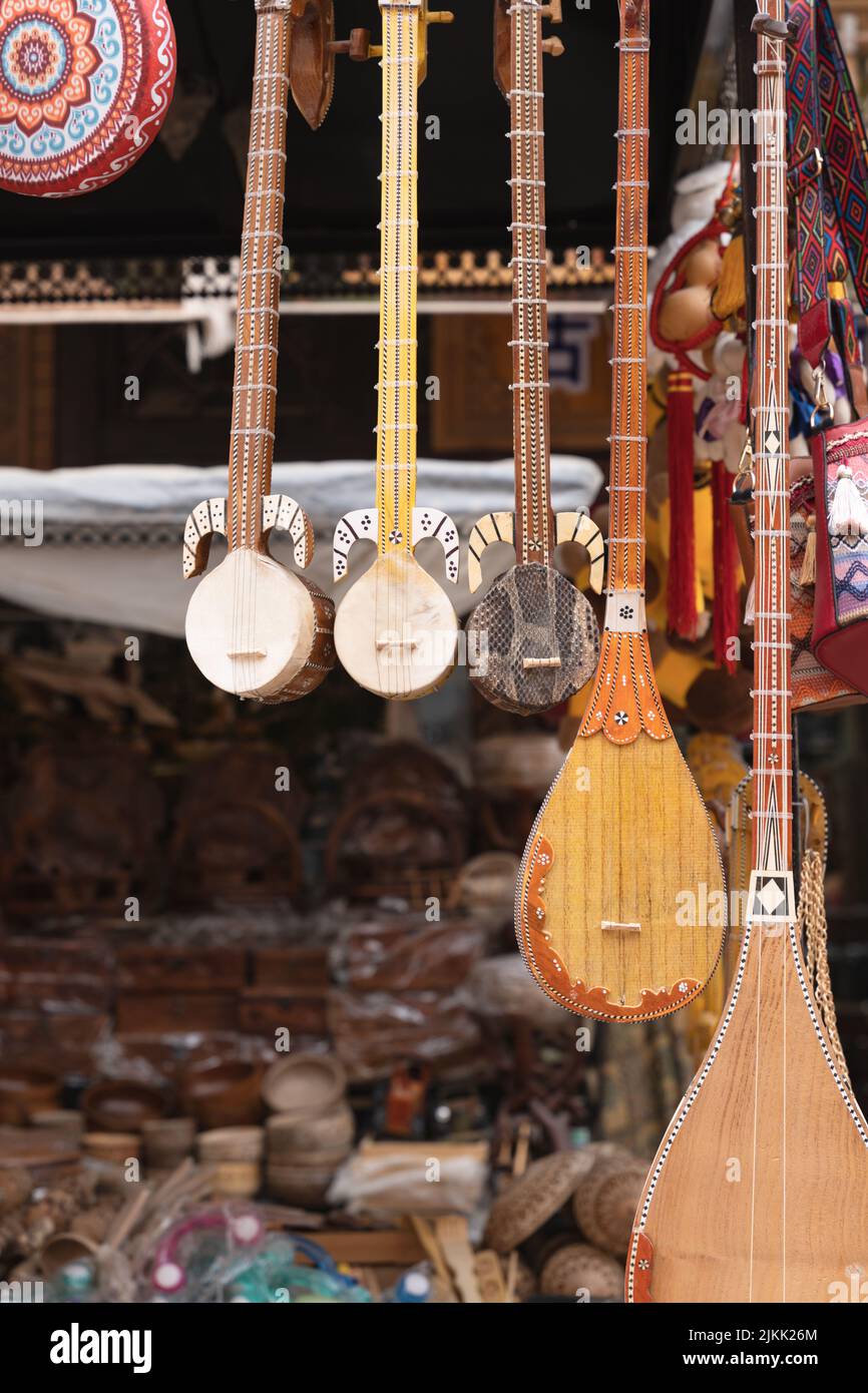 A vertical closeup of string musical instruments hanging in the ...