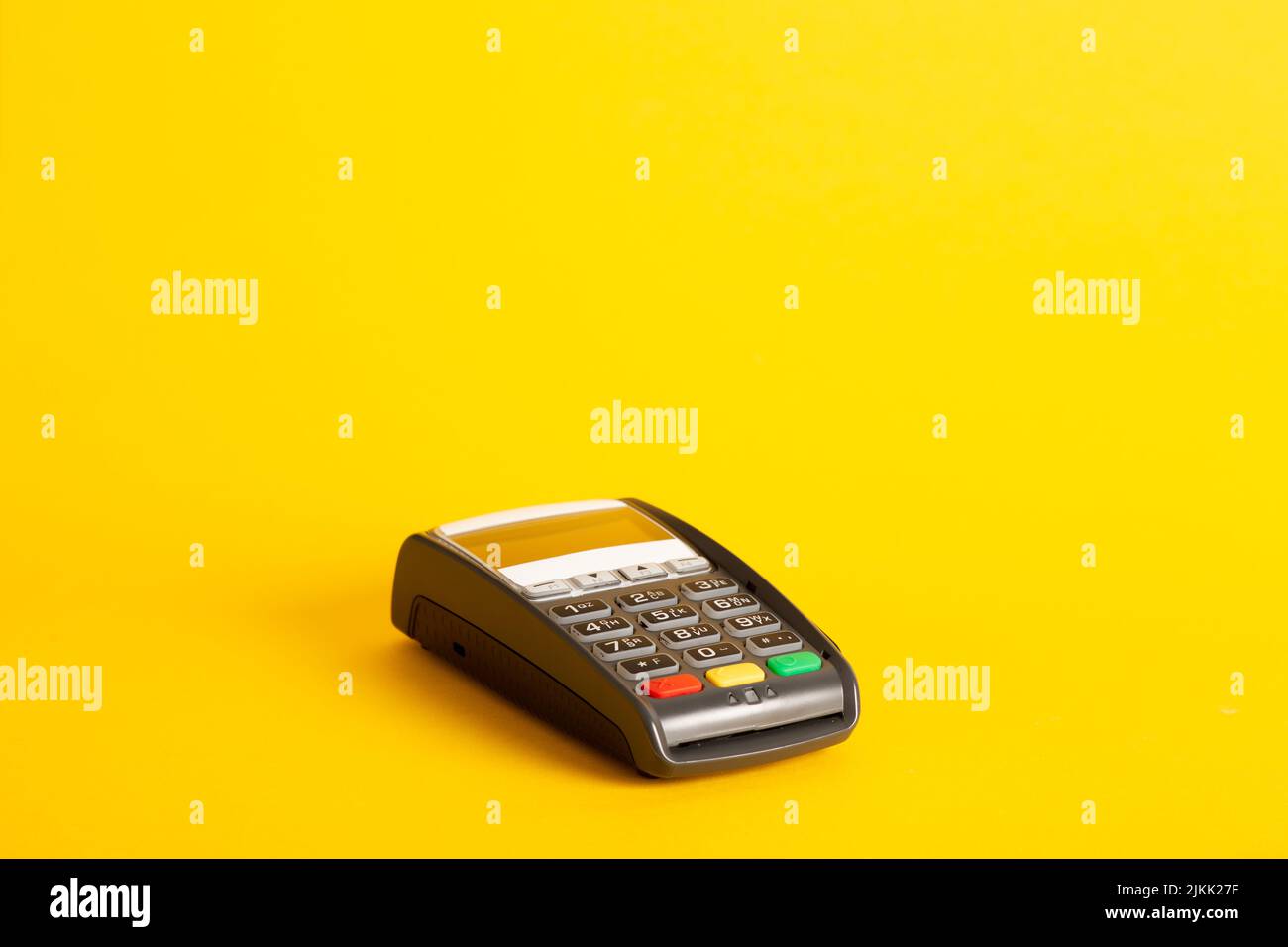 A closeup of an electronic payment terminal isolated on a yellow ...