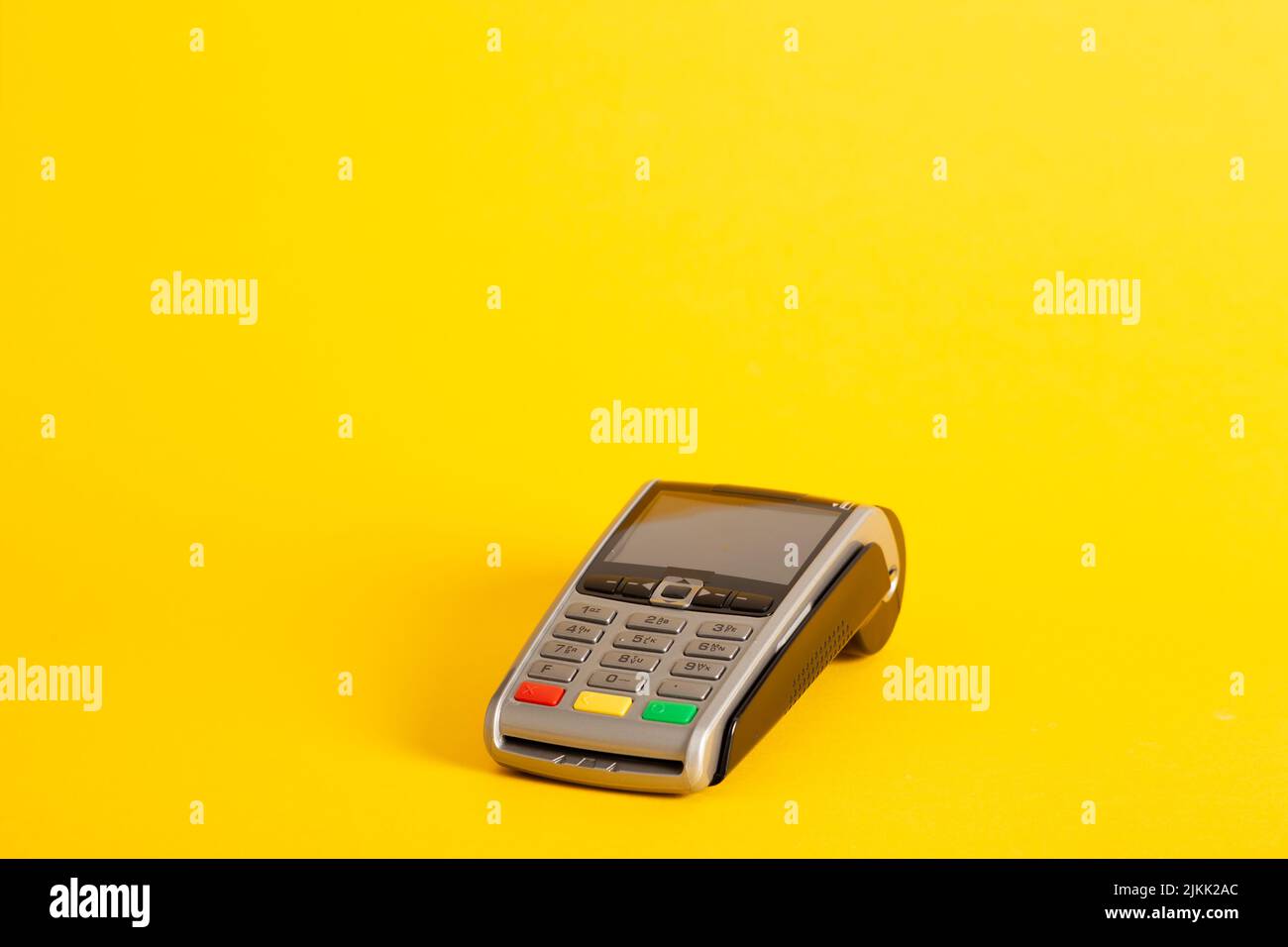 A closeup of an electronic payment terminal isolated on a yellow ...