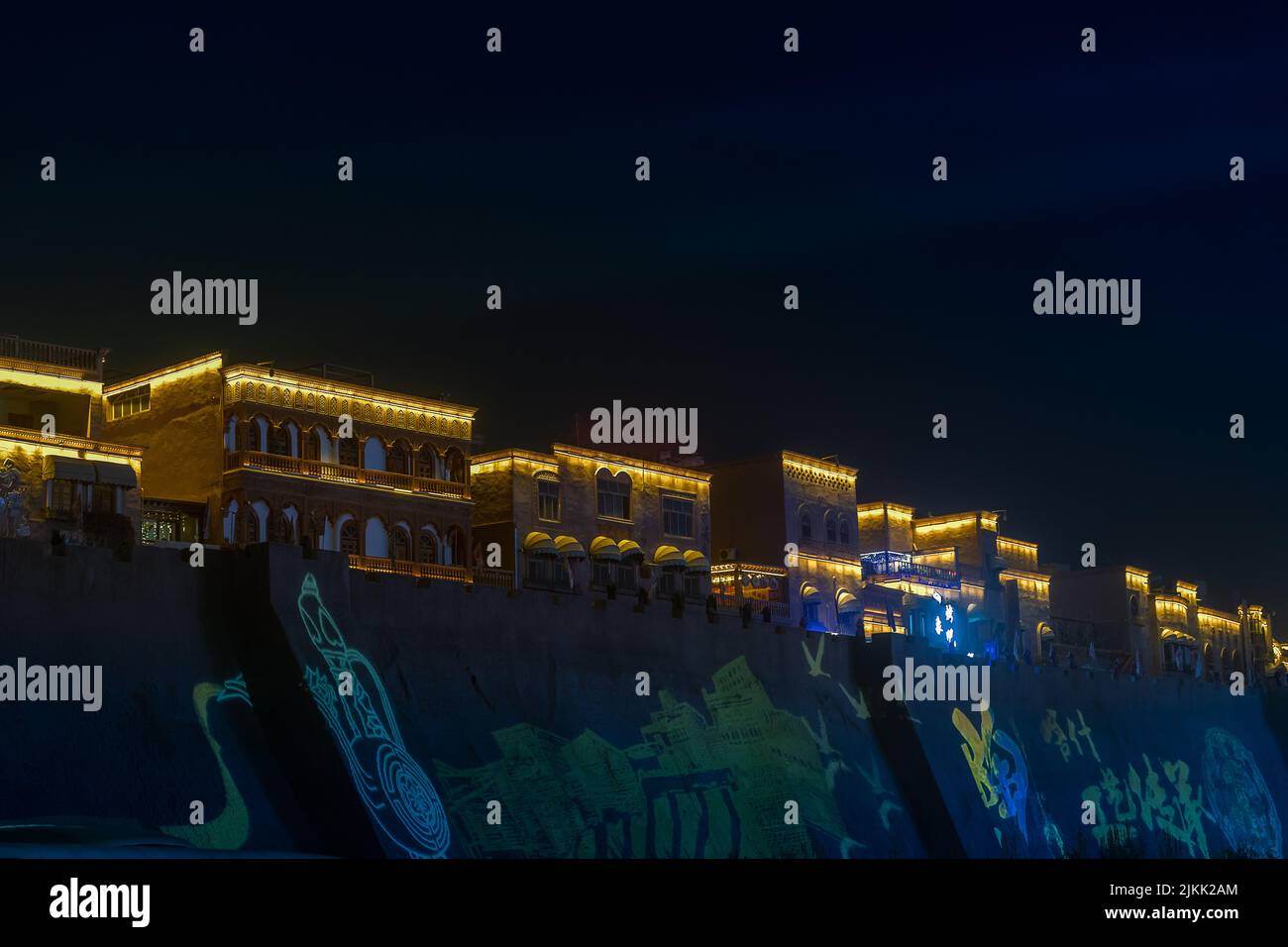 An illuminated city by the wall at night Stock Photo - Alamy