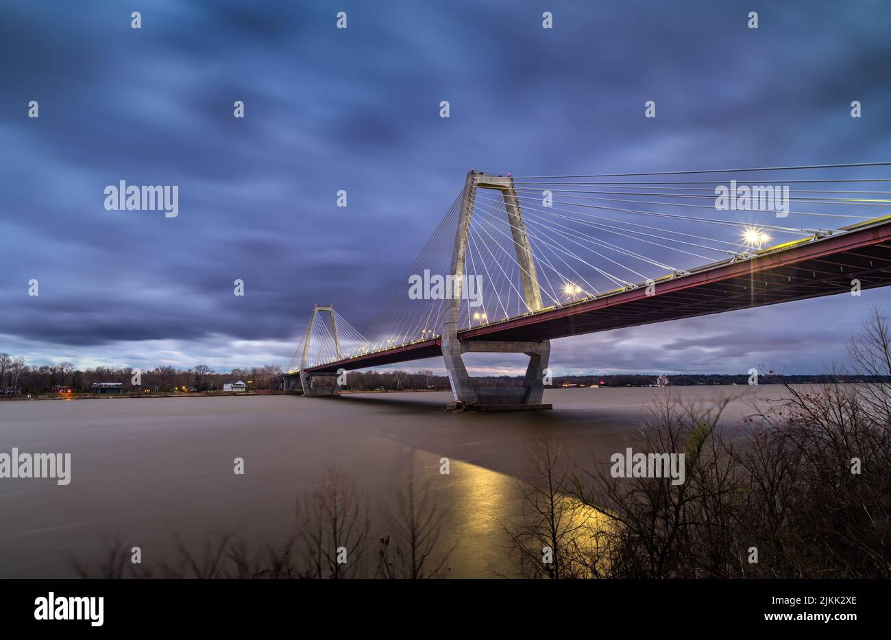 A Vertical shot of bridge over the water during Sunset and a blue ...