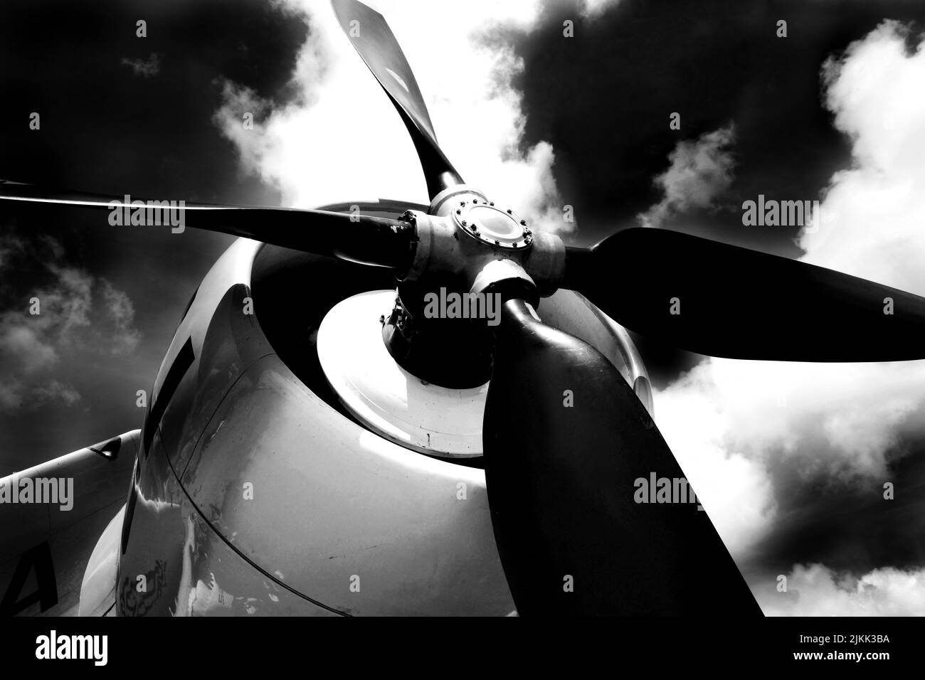 A low angle grayscale shot of an Aircraft motor with fan against a ...