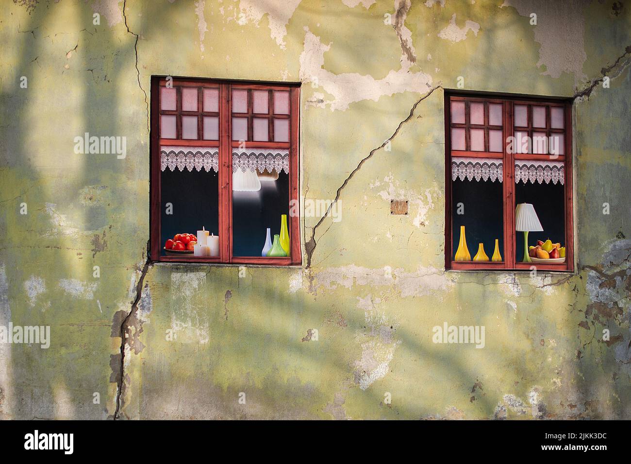 An old stone building with cracks and window frames with paintings ...