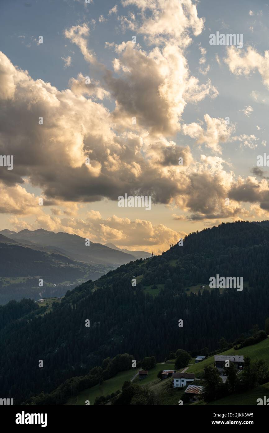 A vertical photo of clouds and mountains in Falera, a municipality in ...