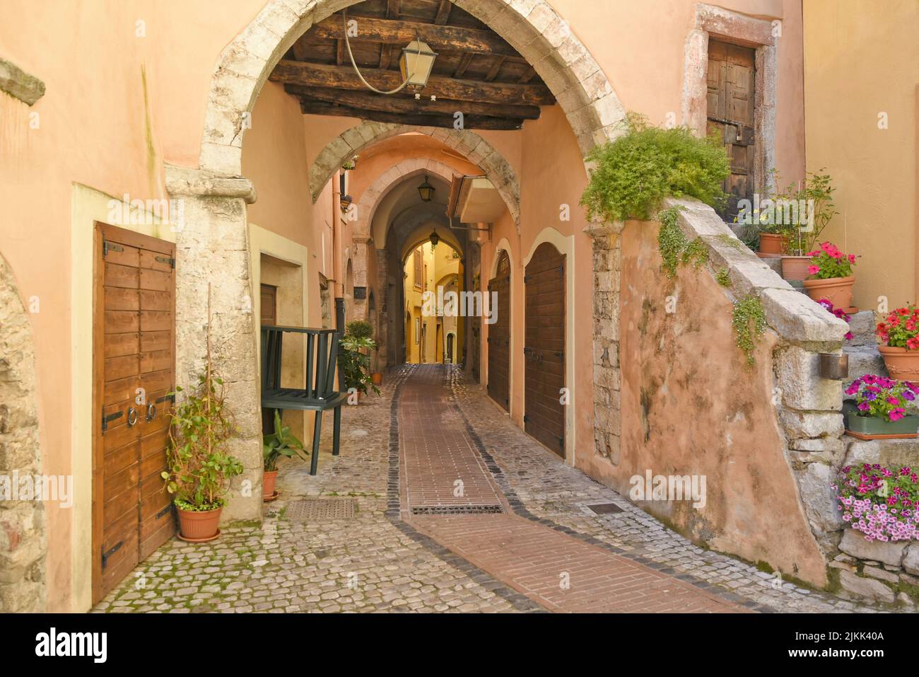 A narrow cobblestone corridor path between old medieval buildings Stock ...