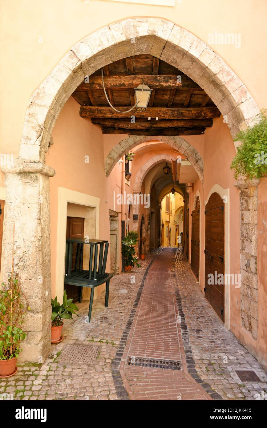 A vertical shot of a narrow cobblestone corridor path between old ...