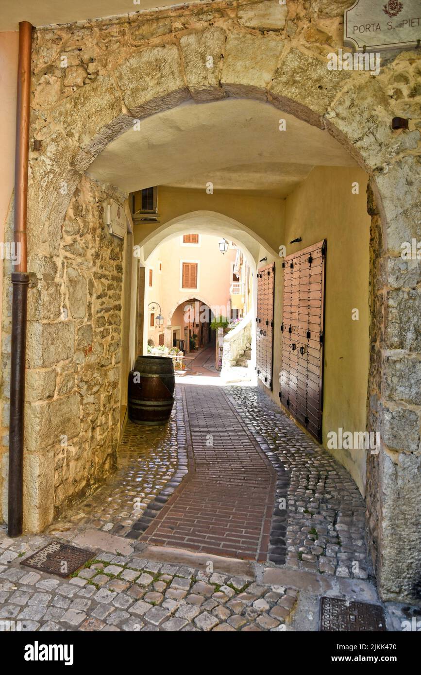 A vertical shot of a narrow cobblestone corridor path between old ...