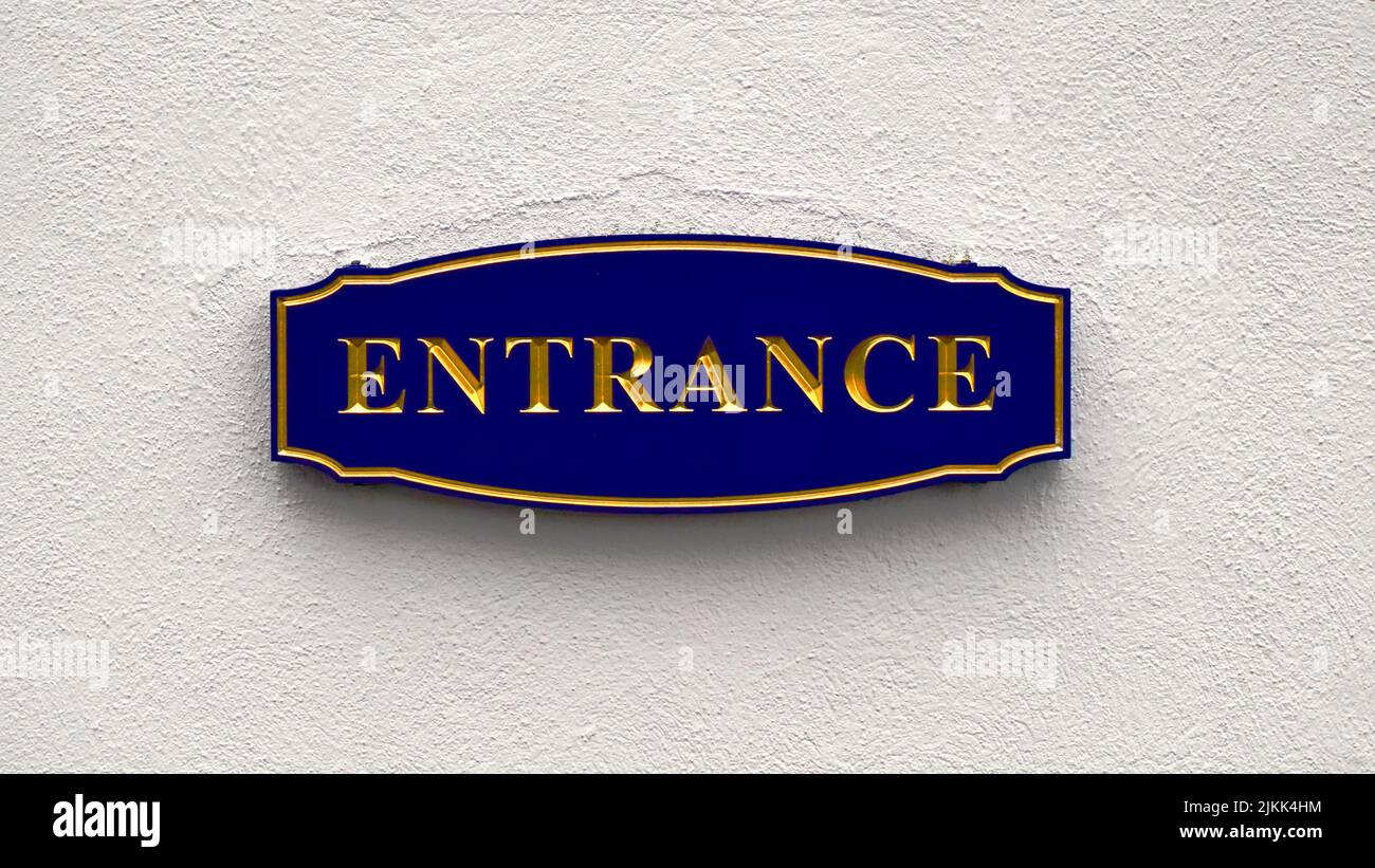 An entrance sign banner on a white wall Stock Photo - Alamy