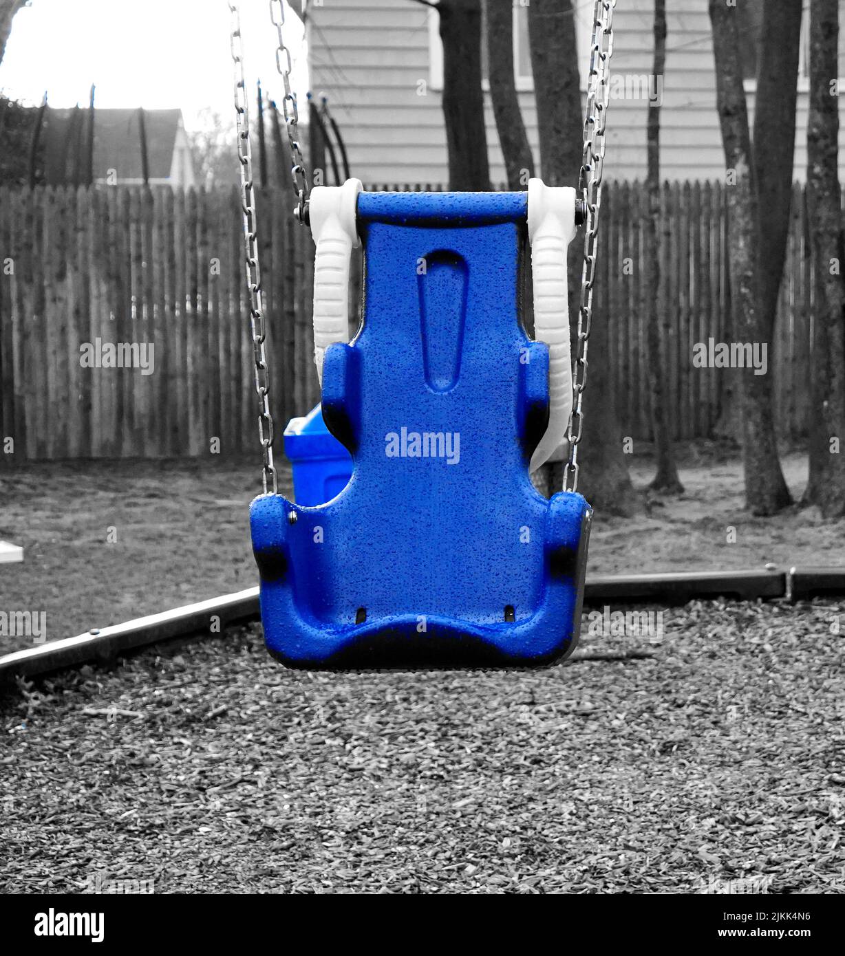 A selective color of a wet blue swing in the park after rain Stock ...