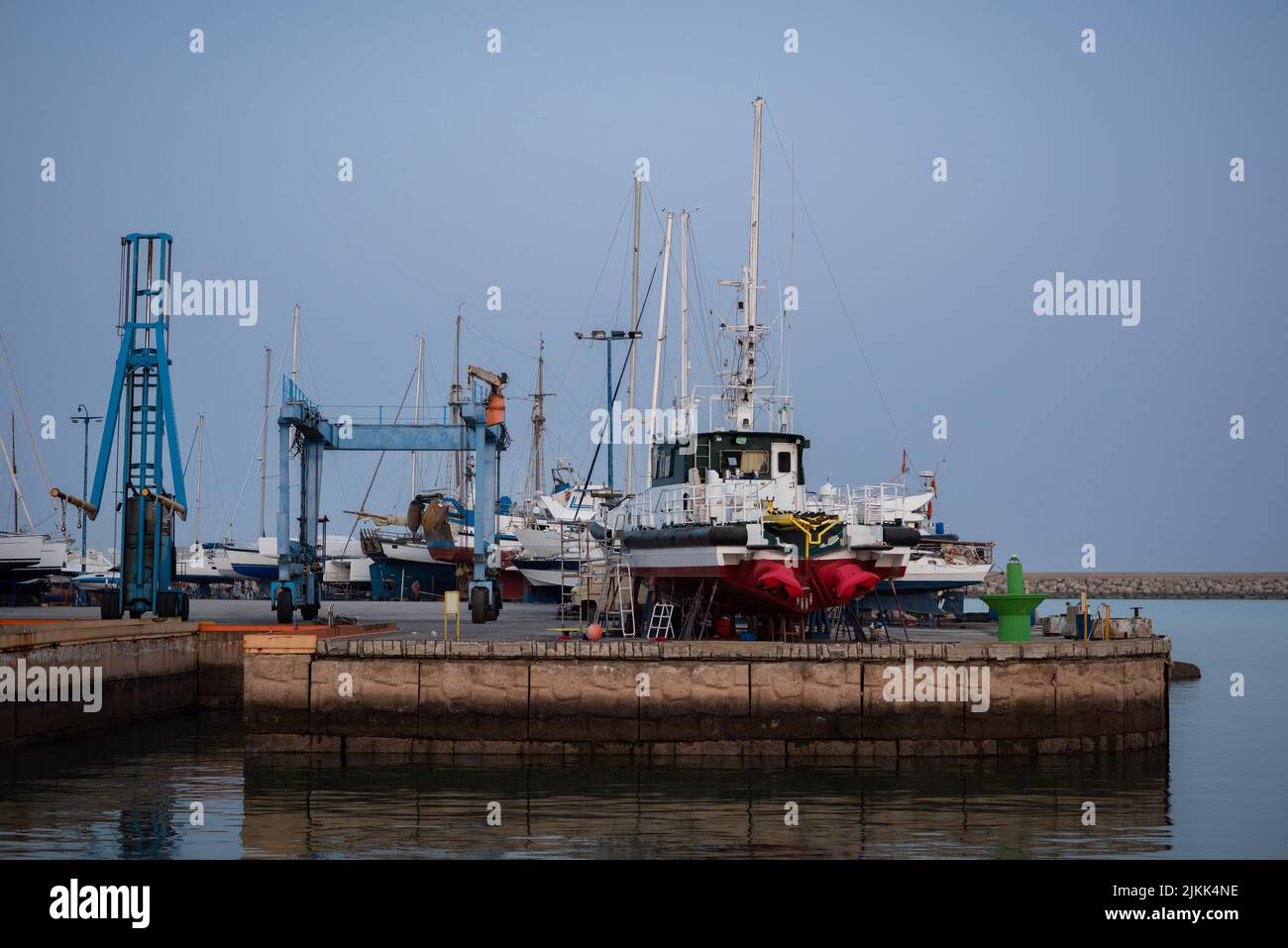 The Sailboats in a harbor and dock machinery Stock Photo - Alamy