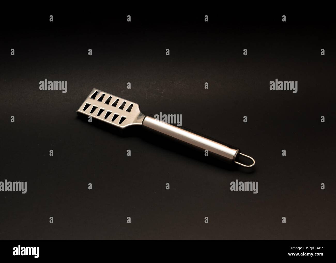 Top view single stainless steel fish scale scraper isolated on black ...