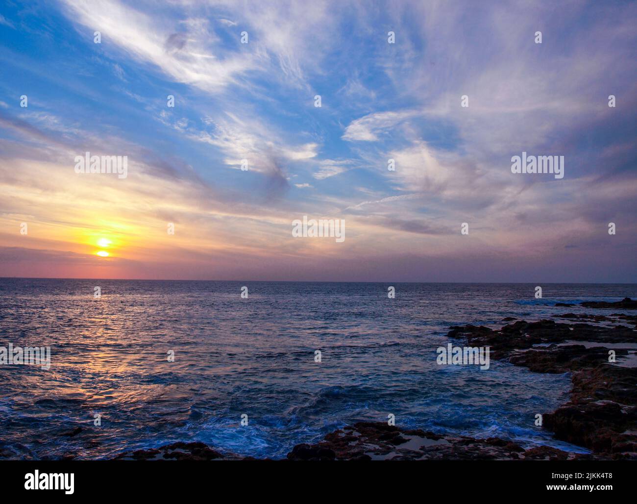 A colorful sunset by the ocean coast Stock Photo - Alamy