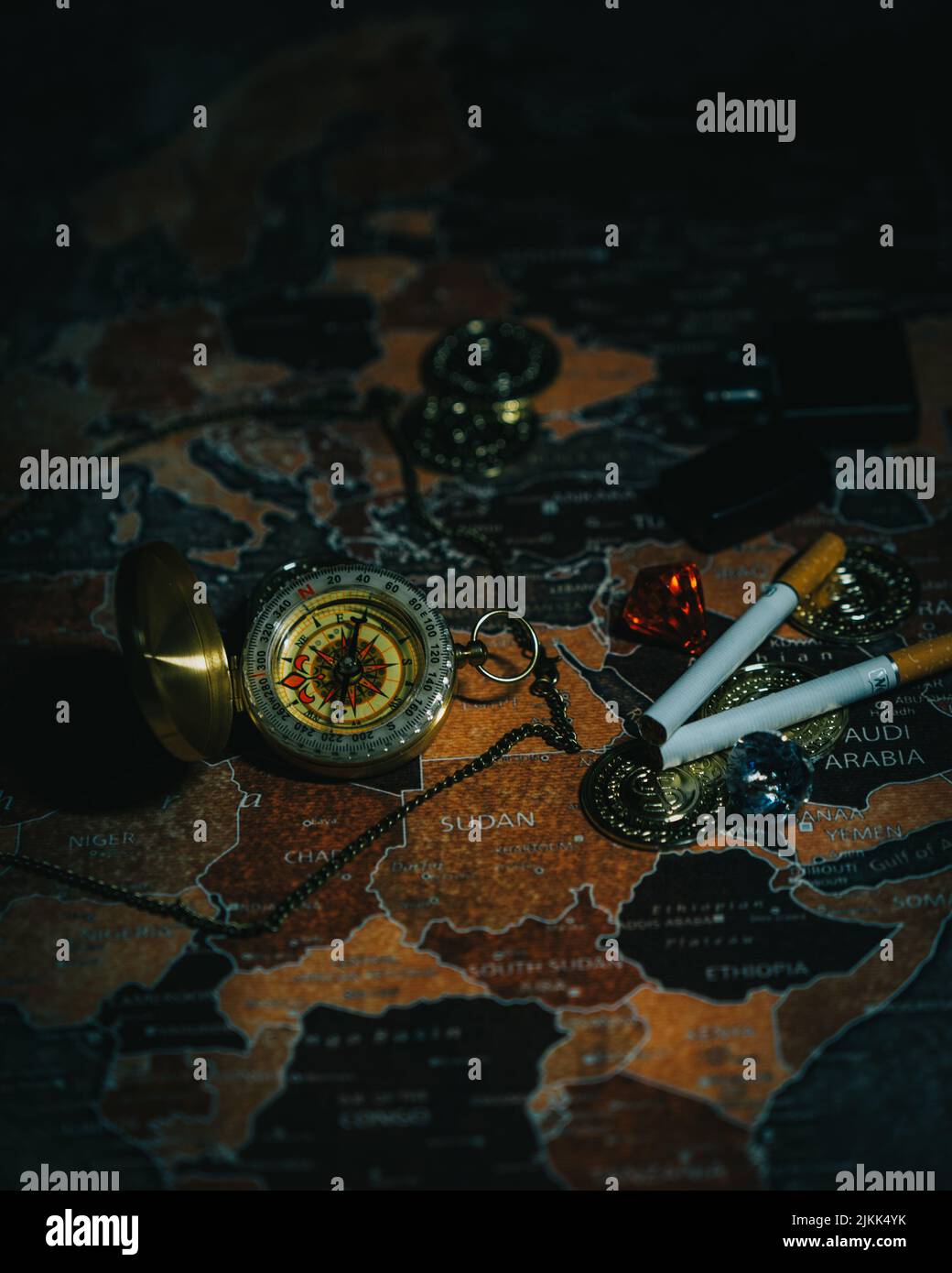 A vertical shot of cigarettes and a compass on a world map Stock Photo ...