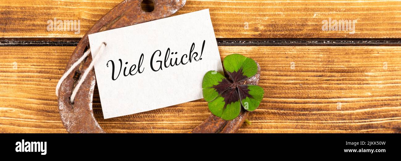 horseshoe with green shamrock sign for luck on a wooden background with ...