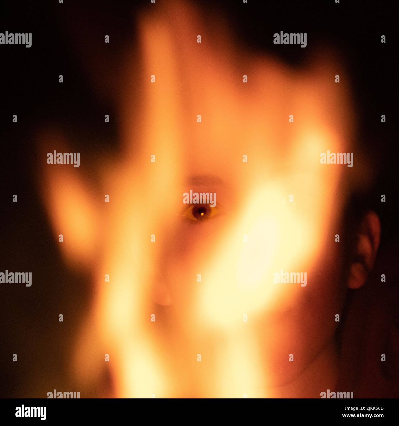 Bright fire flame and a person behind. The concept of hell and ...