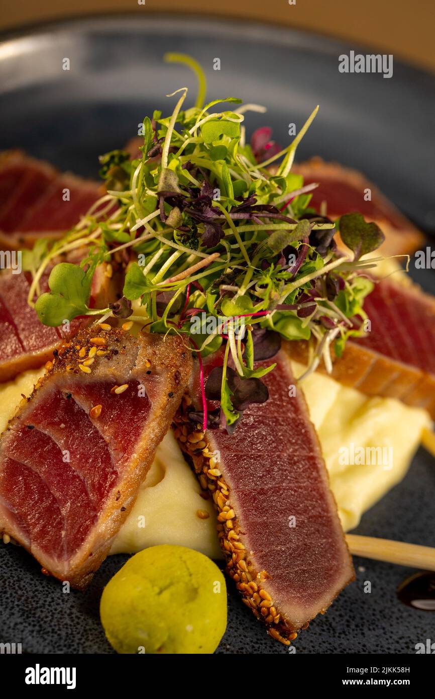 A portion of tataki with fish topped with greens Stock Photo - Alamy
