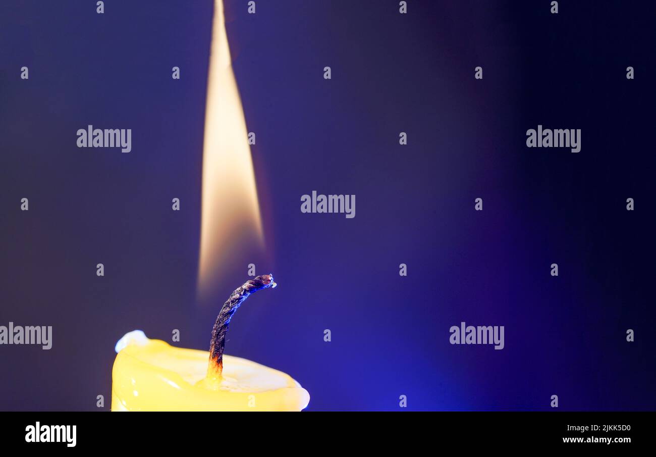 A closeup of the candlelight against the dark blue background Stock ...