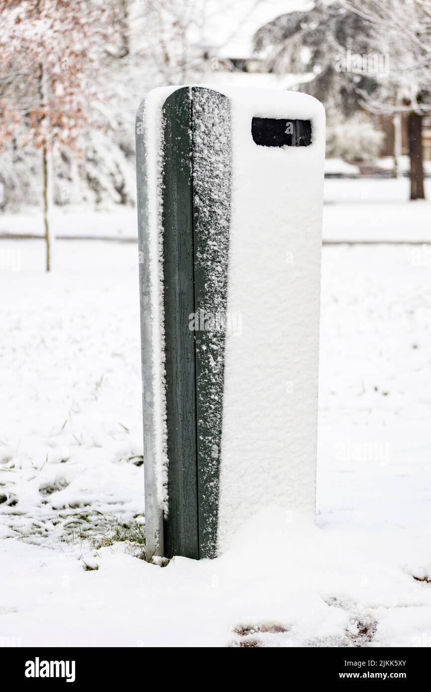 Trash can waste bin in Oog in Al park covered in thick layer of snow in ...