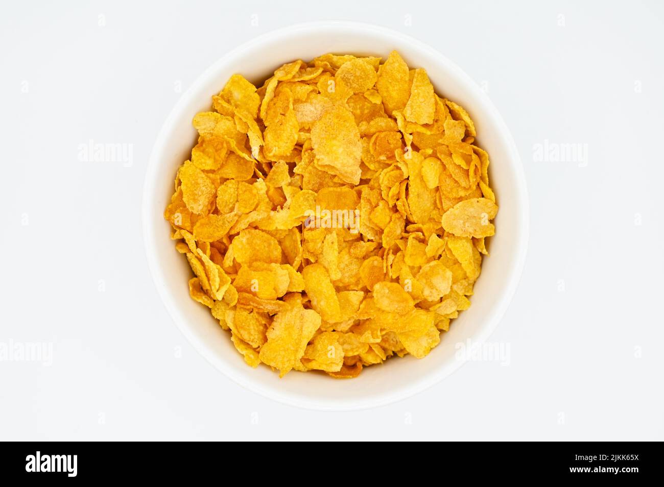A top view of crunchy corn flakes in a bowl isolated on a white surface ...