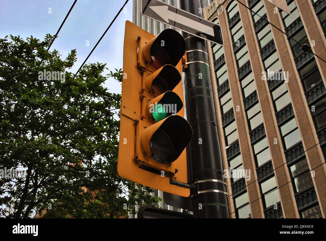 A low angle shot of a traffic light with an arrow pointing right on a ...