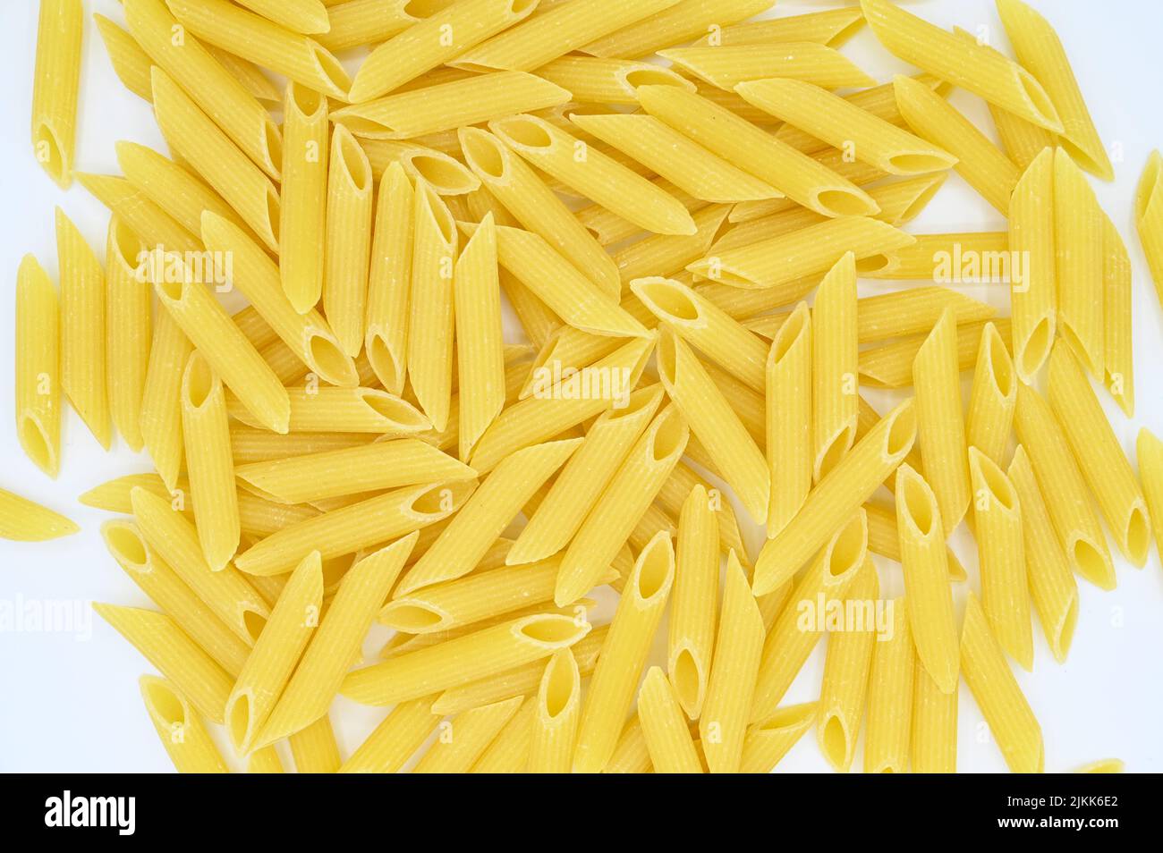 A top view of raw penne pasta on a white background Stock Photo - Alamy