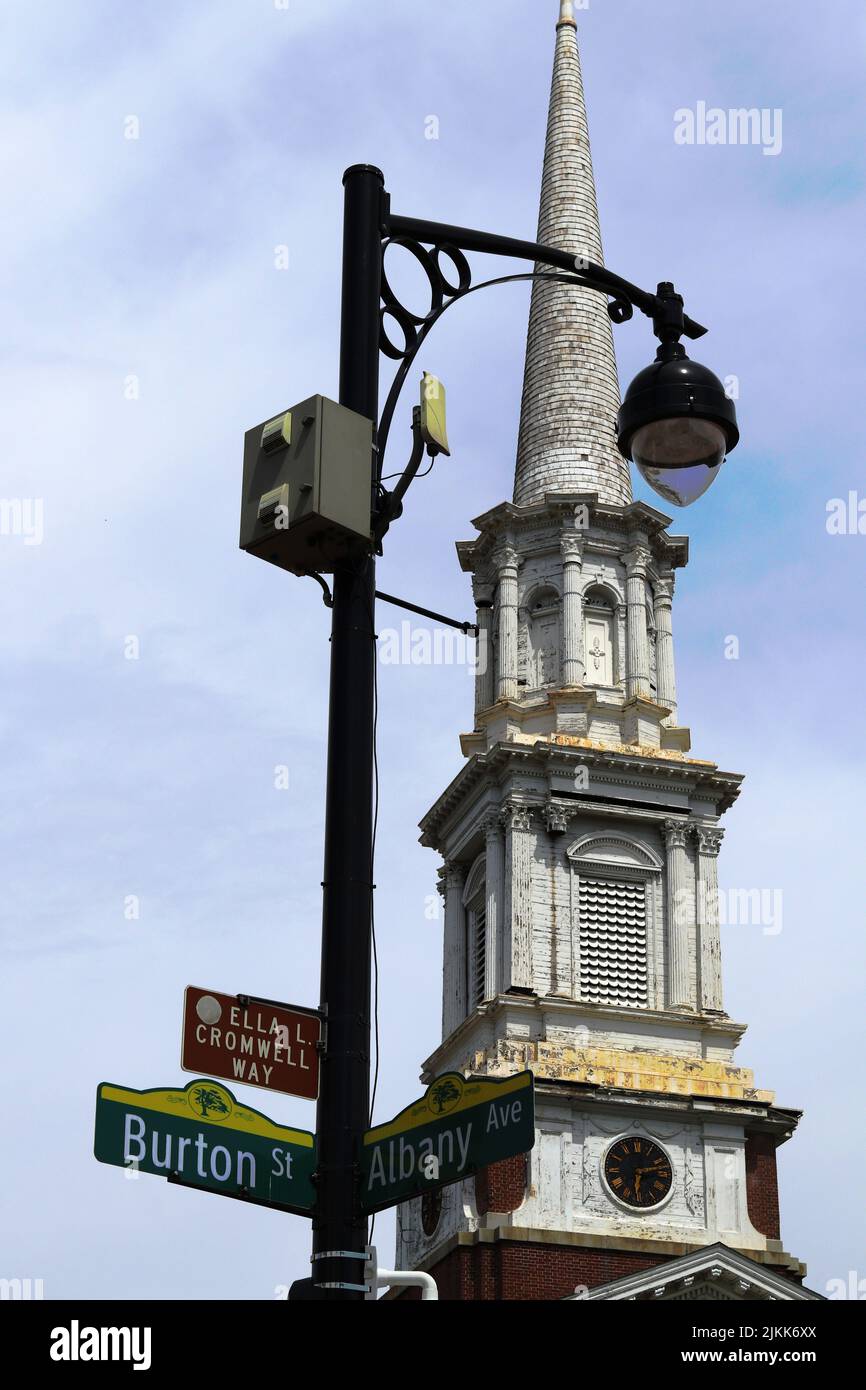 A vertical shot of a lamp post with street signs in Hartfold ...