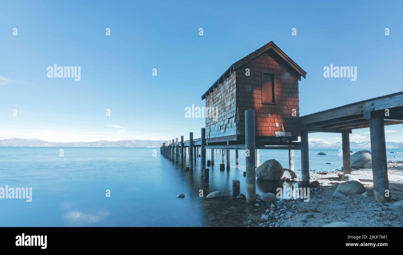 a low angle shot of small house on a pier in water Stock Photo - Alamy