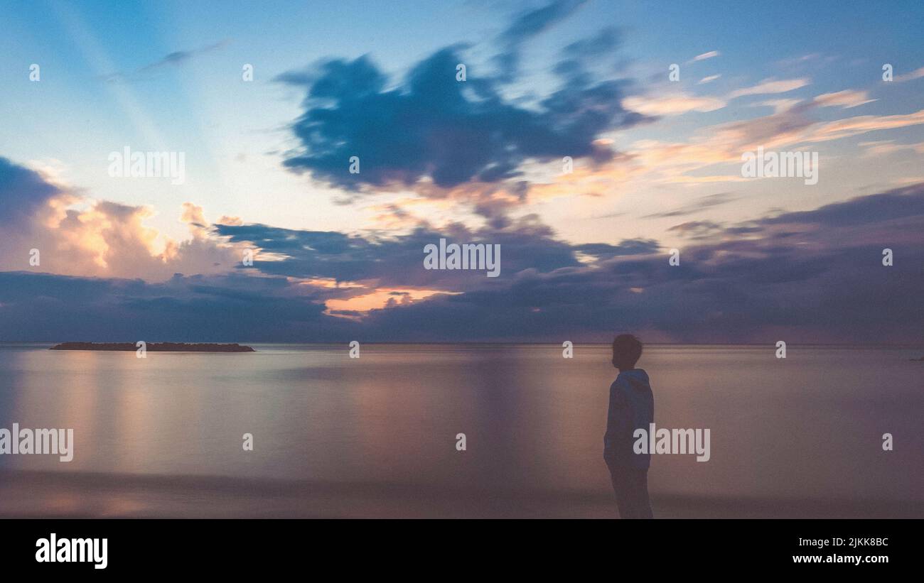 The view of the silhouette of a man in the sea reflecting sunset Stock ...