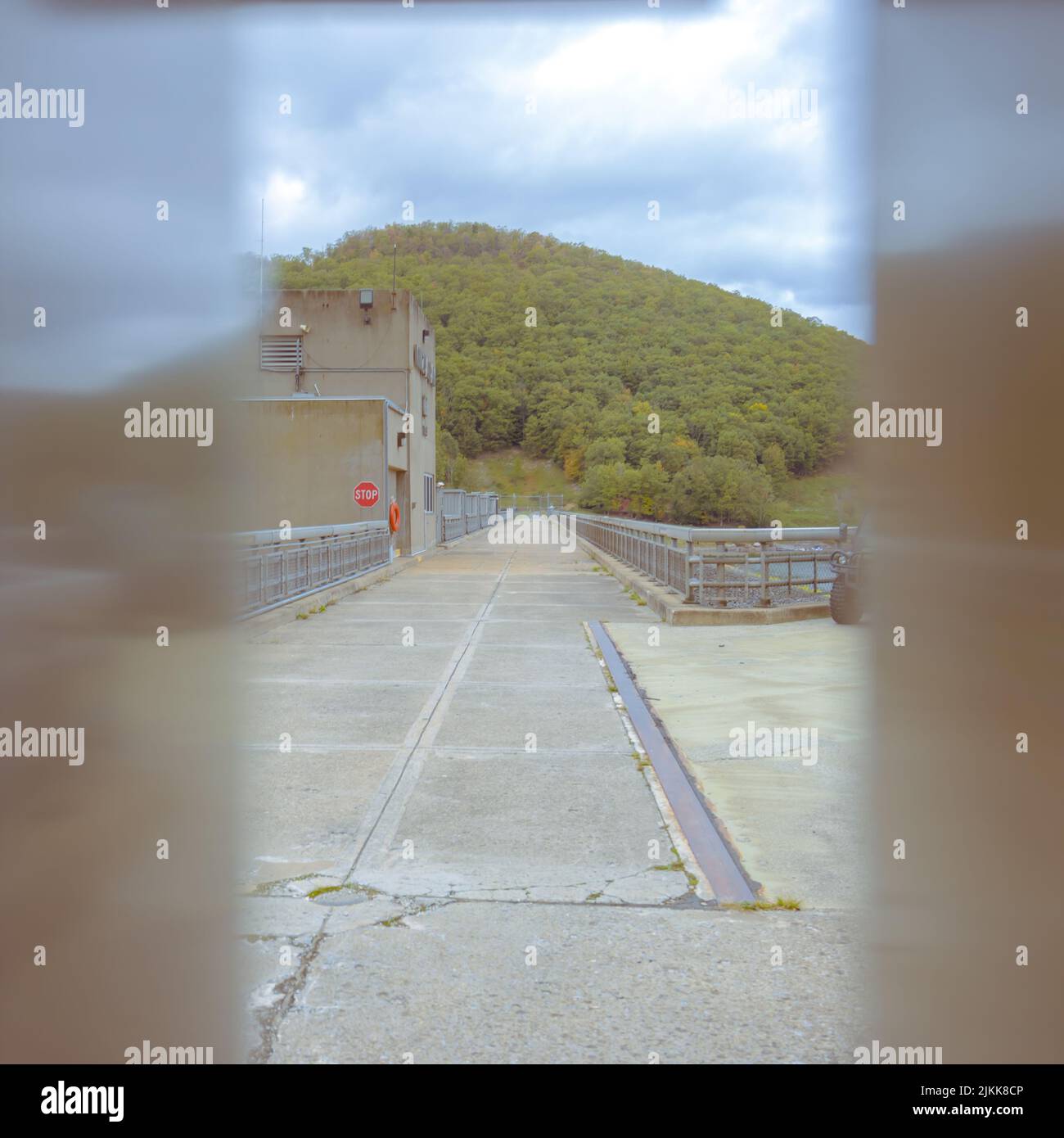 A vertical view from a narrow opening of a bridge directed to a parking ...