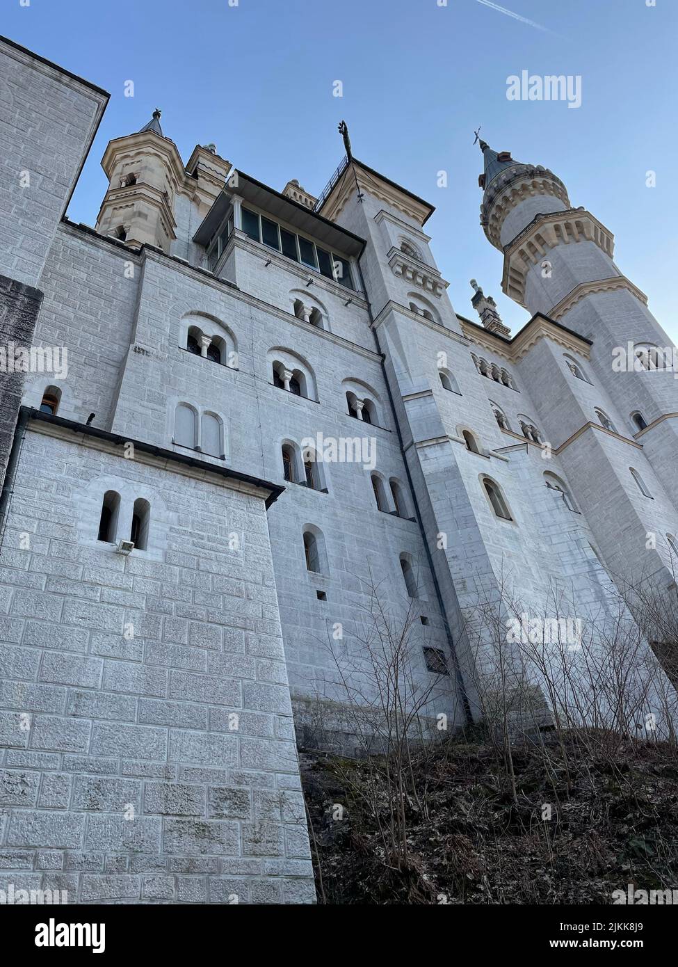 A vertical shot of historic old castle with high towers cross on its ...