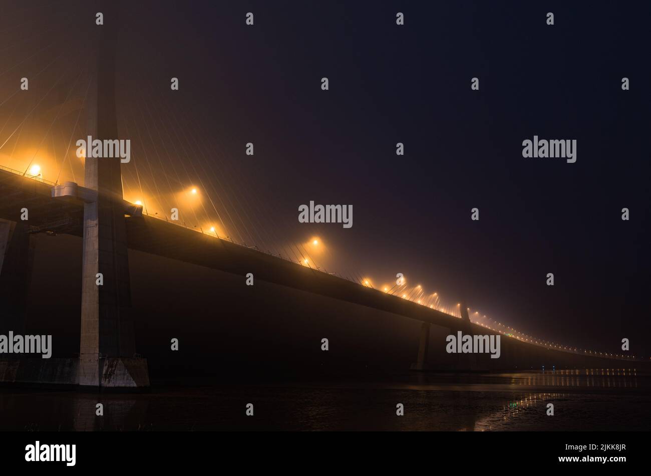 A night landscape view with fog on Vasco da Gama bridge with street ...