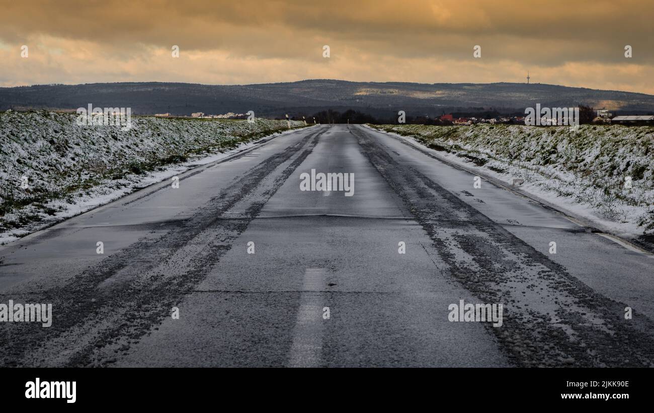 A chilling view of a snow-covered field and road in the countryside ...