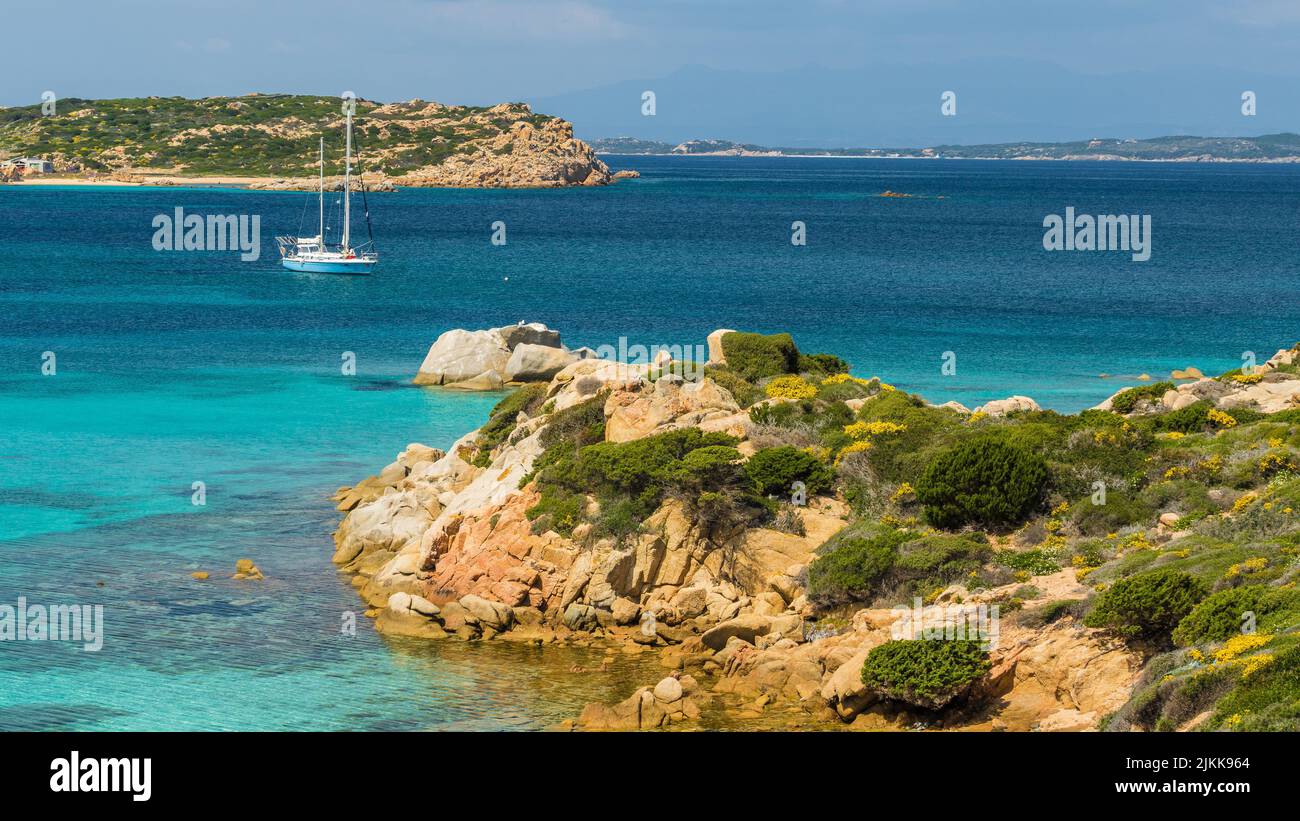 The beautiful view of the rocky shore and the boat sailing on the sea ...