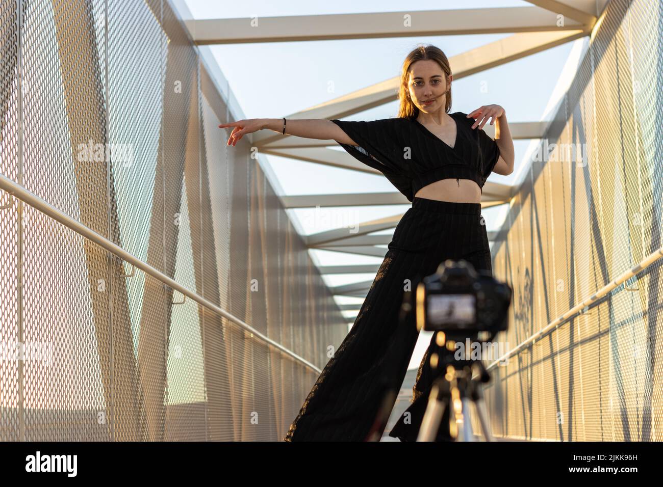 portrait of a young blonde Caucasian woman filming dance classes with ...