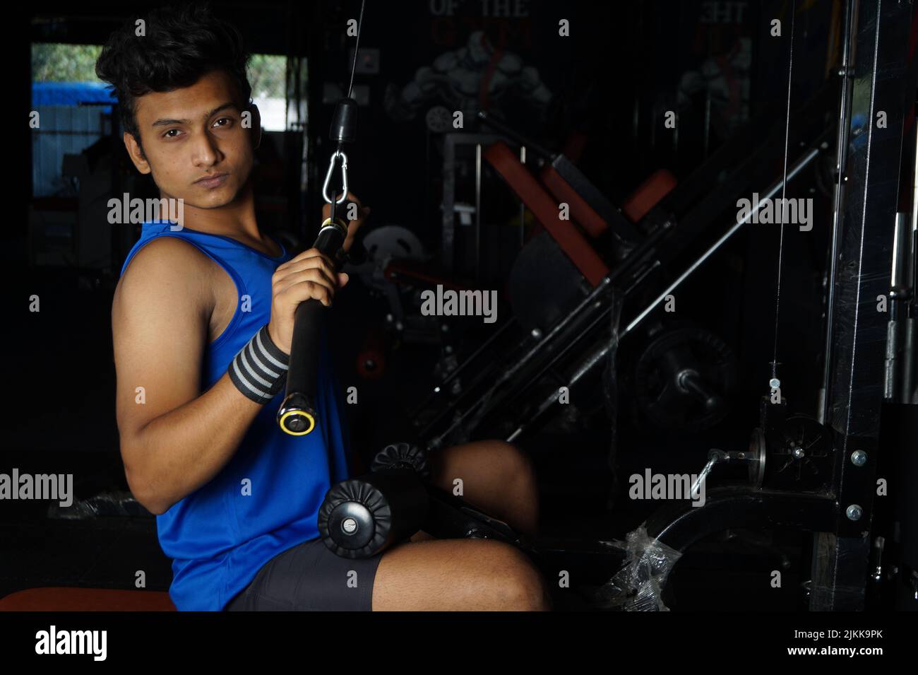 A shallow focus shot of an Indian young male training on a lat pulldown ...