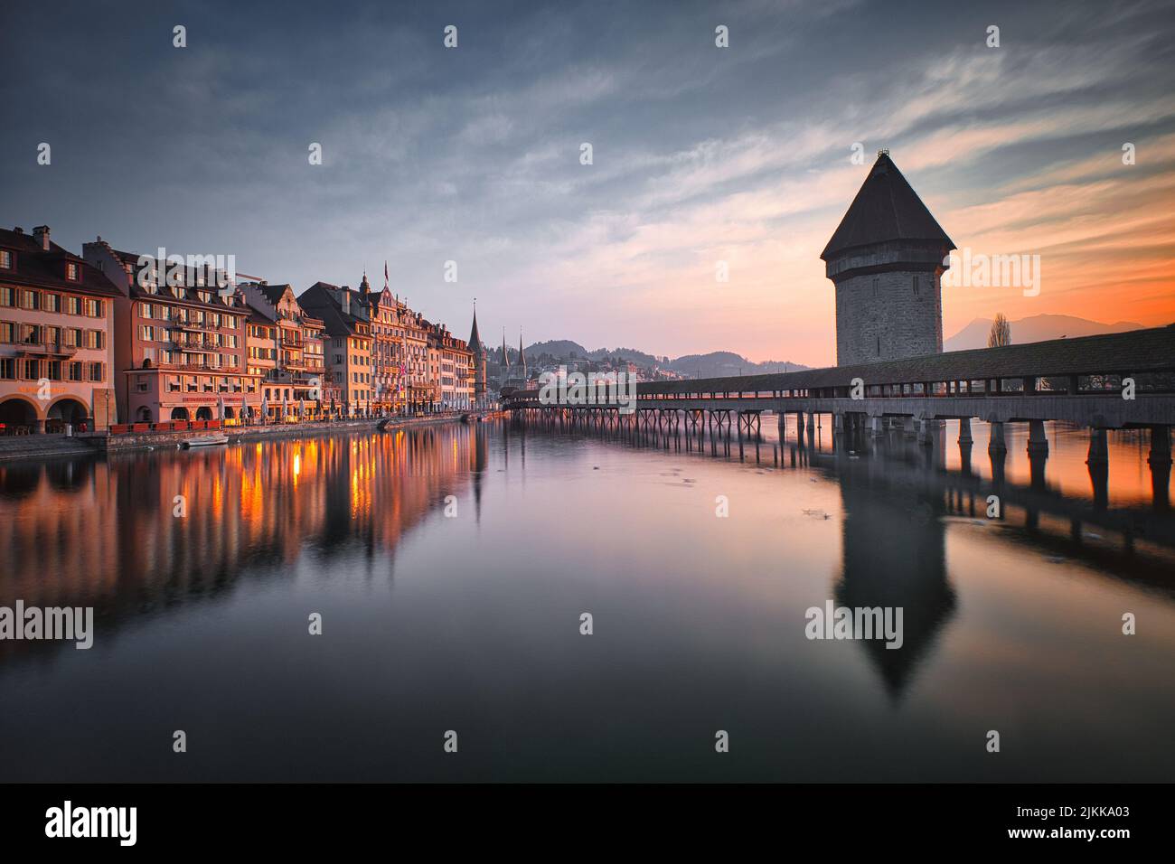 A scenic shot of the Lucerne bridge during the evening surrounded by ...